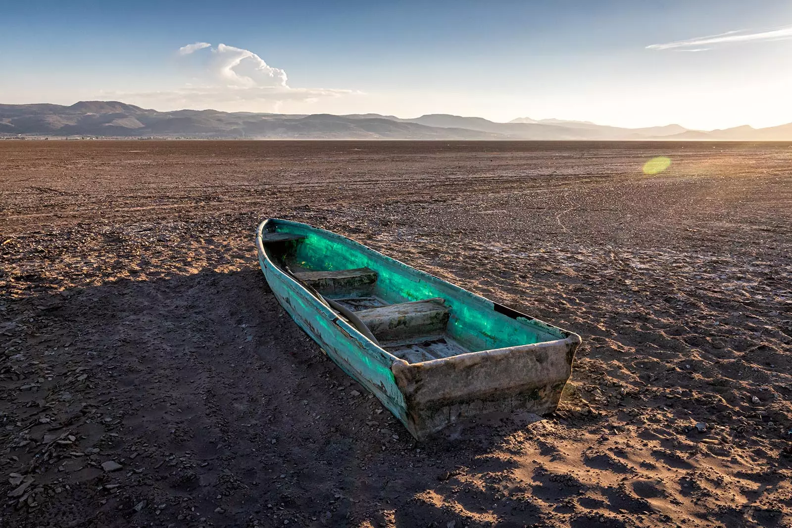 A lone boat sits in the middle of a dried out lake bed in Michoacan, Mexico.