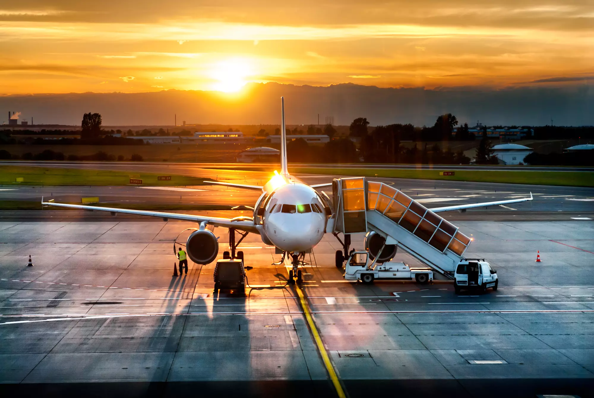 Airplane near the terminal in an airport at the sunset